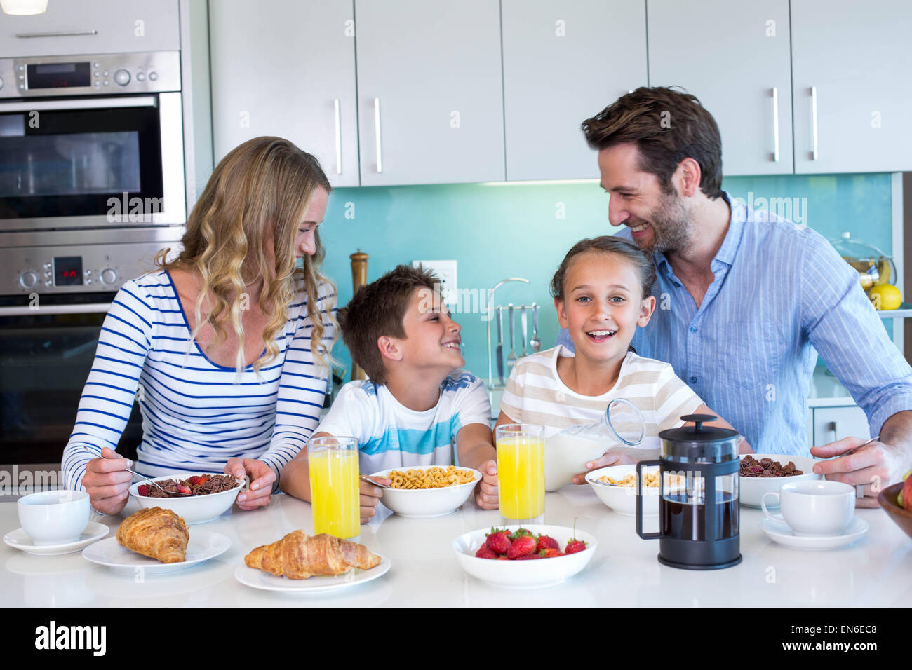 Happy family having breakfast together Stock Photo - Alamy