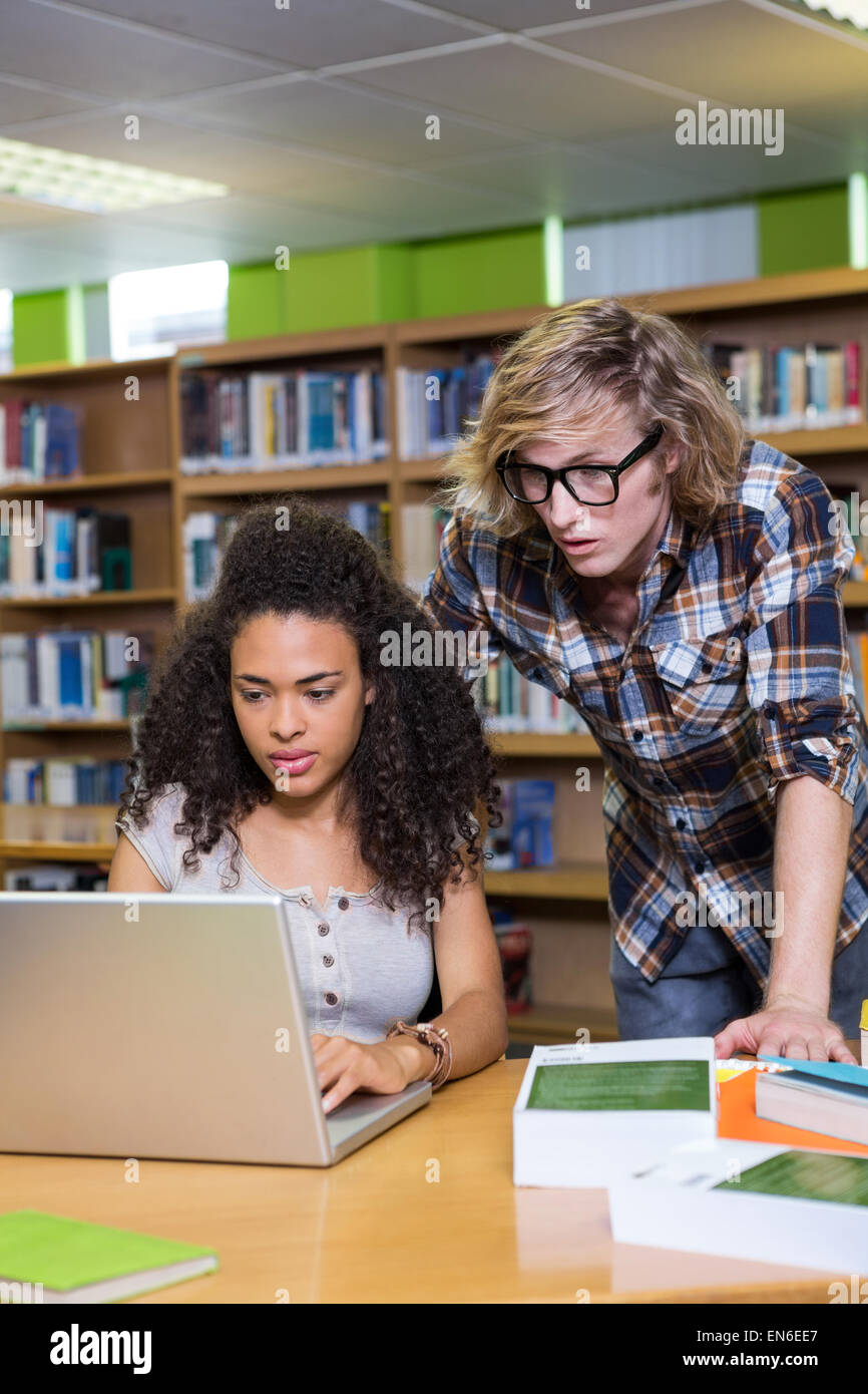 Student getting help from classmate in library Stock Photo - Alamy