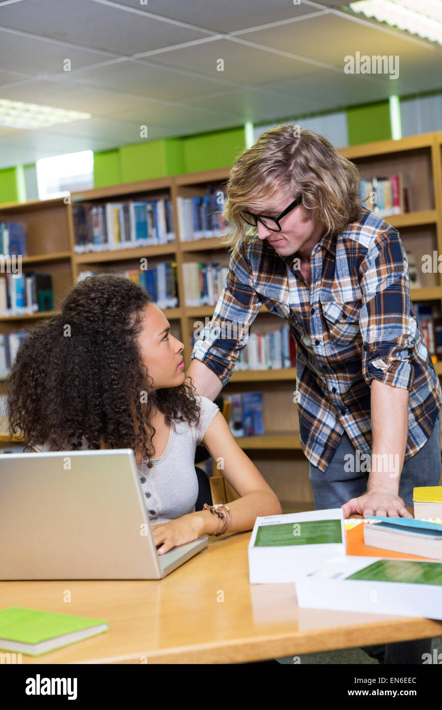 Student getting help from classmate in library Stock Photo - Alamy