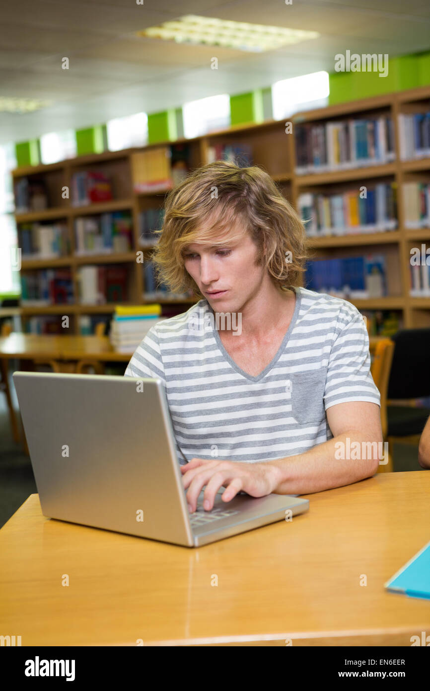 Student studying in the library with laptop Stock Photo - Alamy