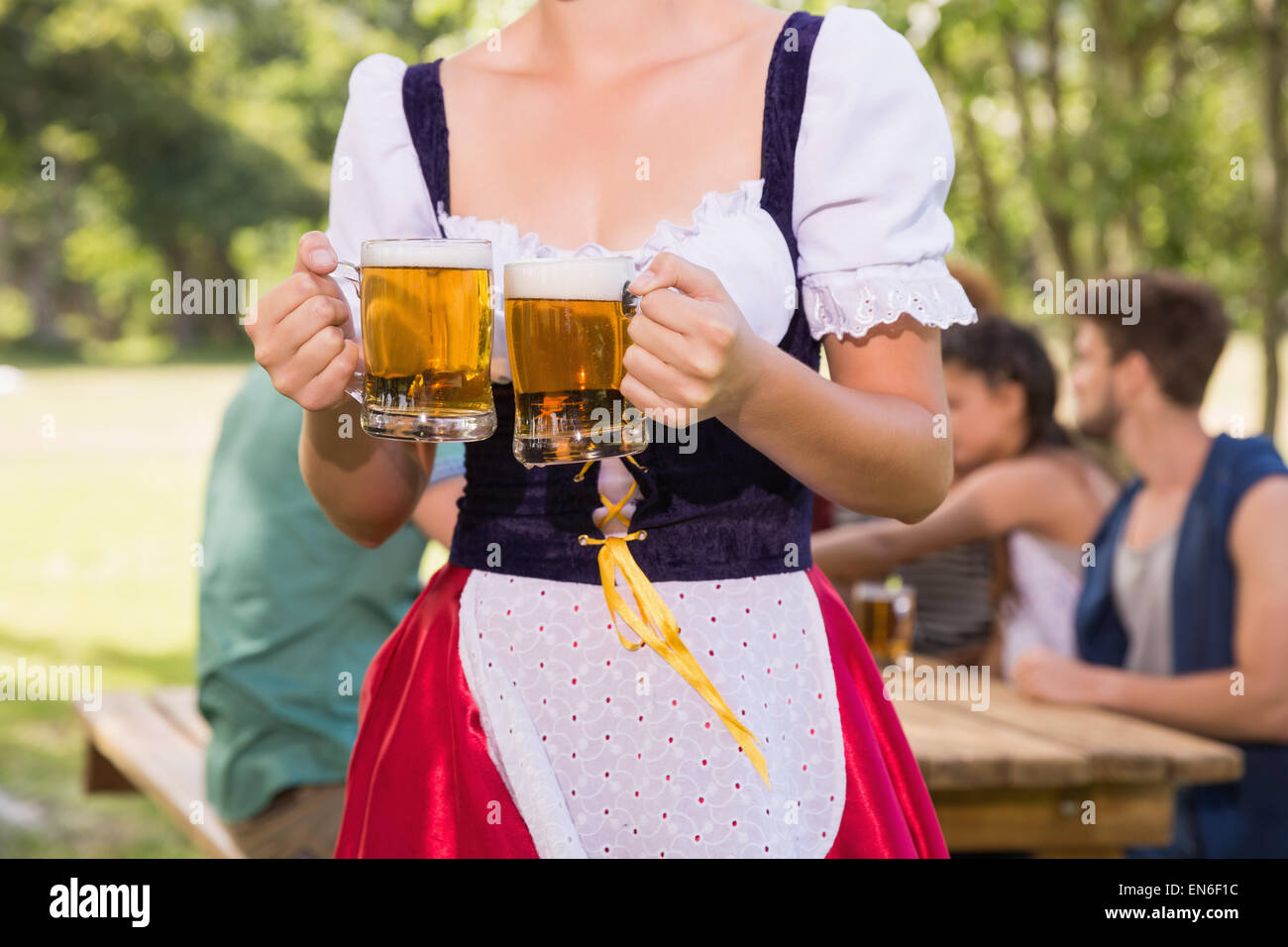 Pretty oktoberfest girl holding beer tankards Stock Photo - Alamy