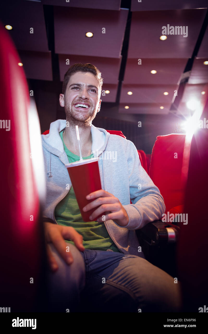 Happy young man watching a film Stock Photo - Alamy