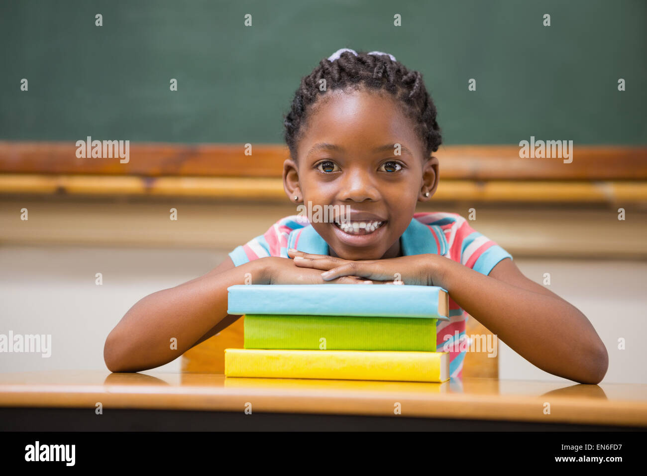Smiling pupil sitting at her desk Stock Photo - Alamy