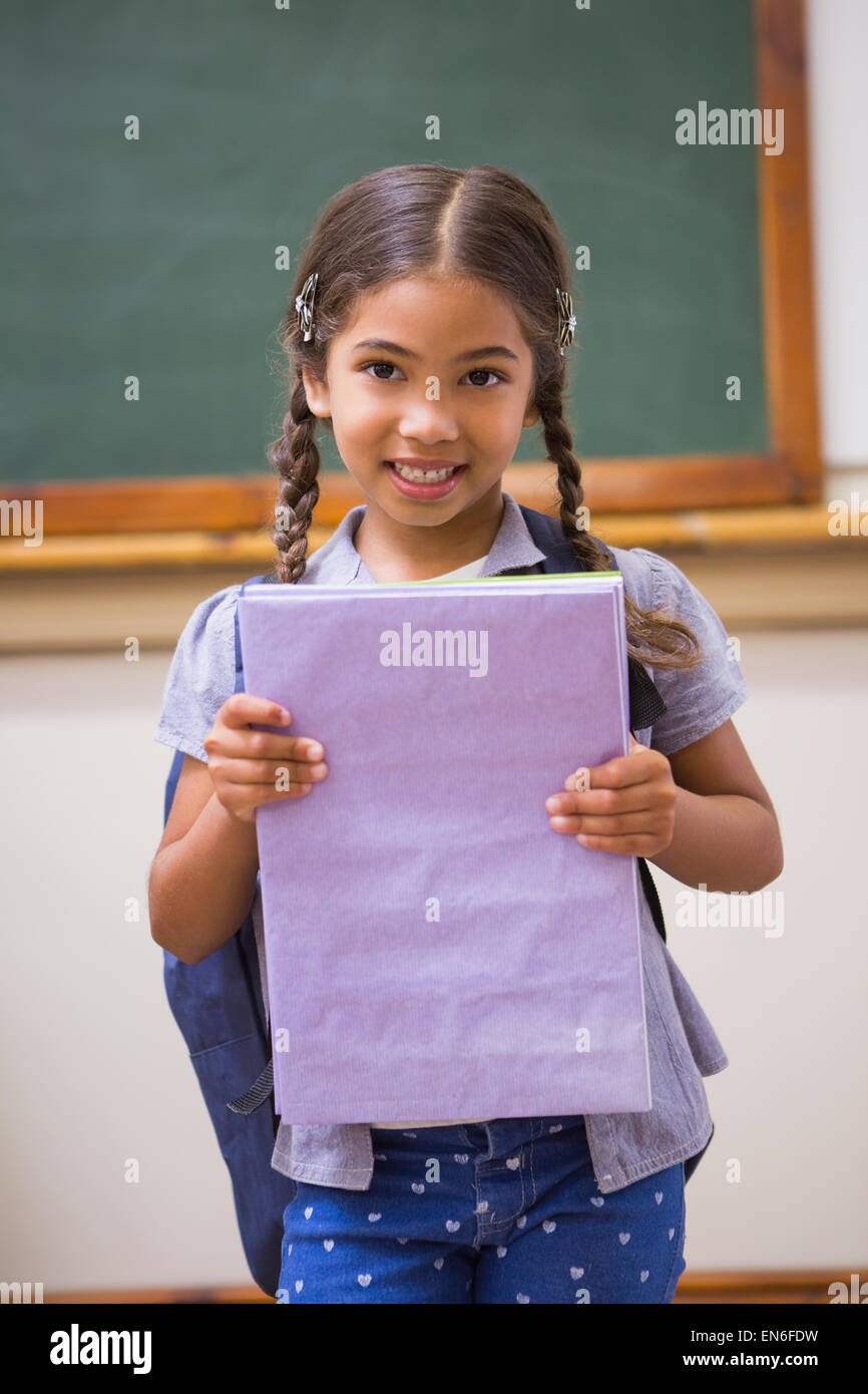 Cute pupil smiling at camera holding notepad Stock Photo - Alamy
