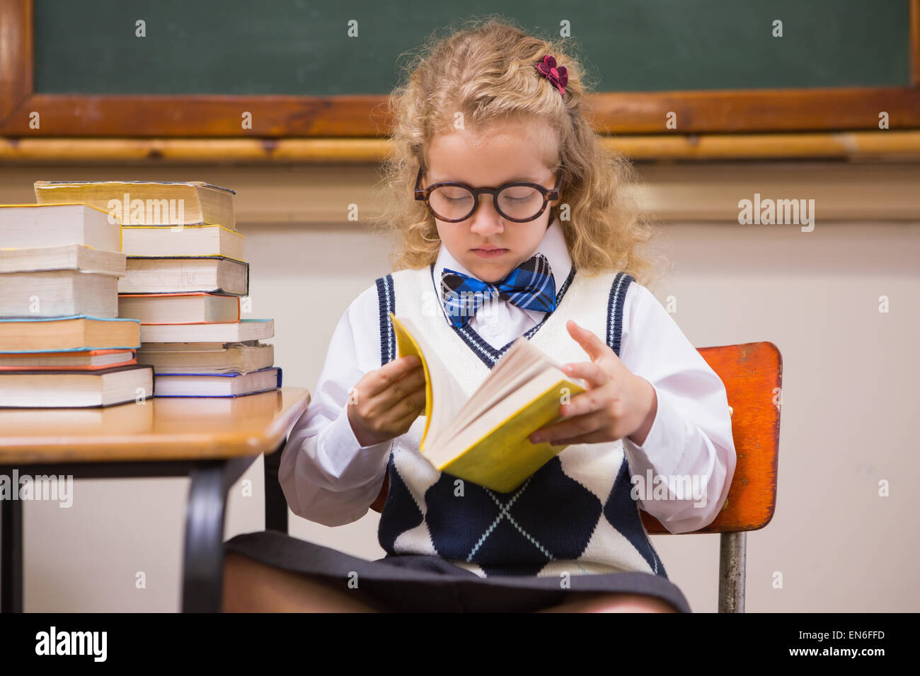 Blonde pupil reading a book Stock Photo - Alamy