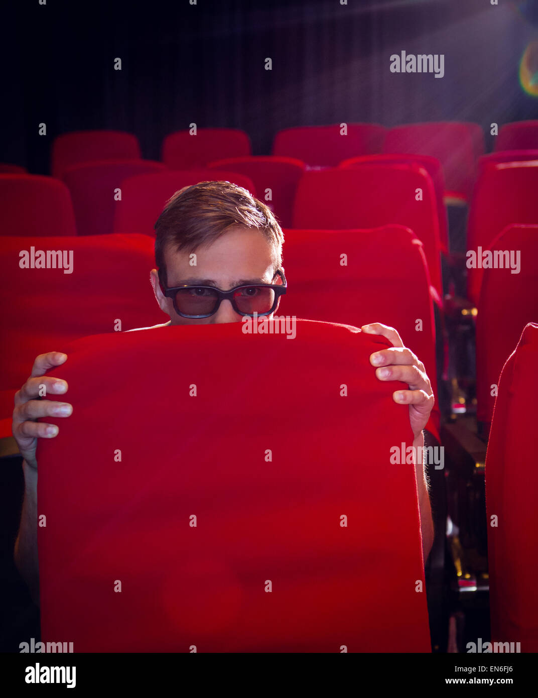 Young man watching a scary 3d film Stock Photo - Alamy