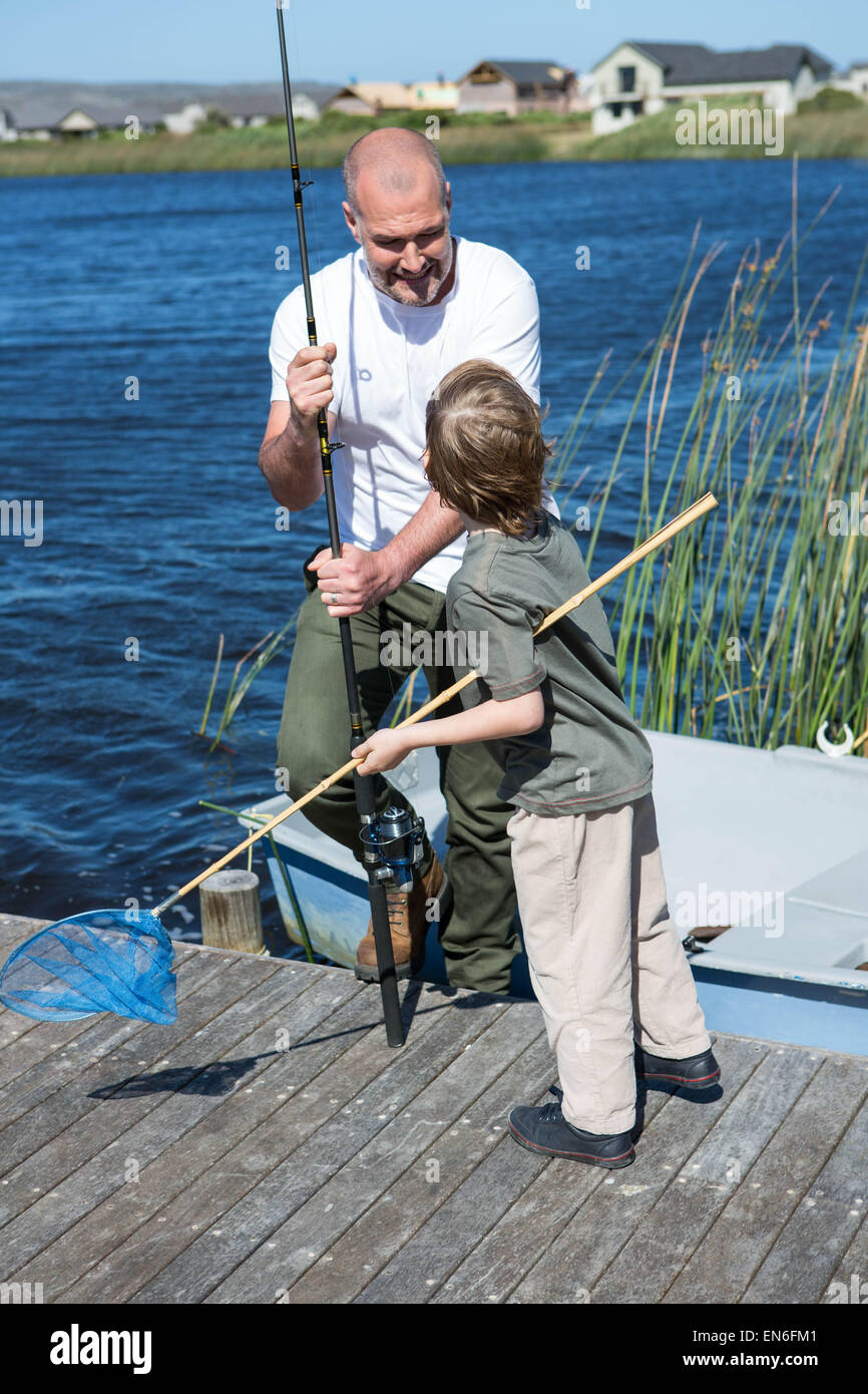 Happy man fishing with his son Stock Photo - Alamy