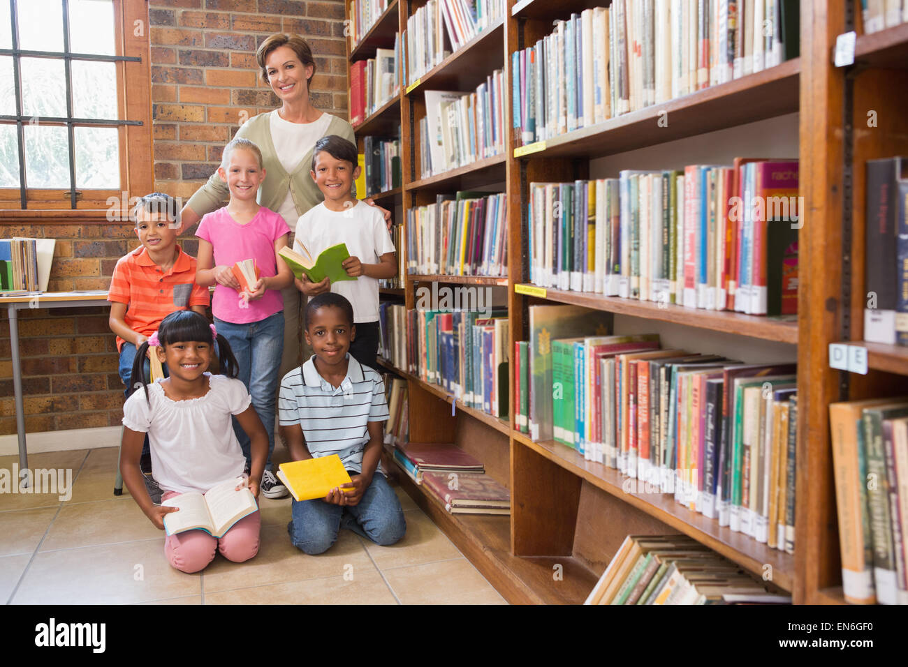 Pupils smiling camera in library hi-res stock photography and images ...