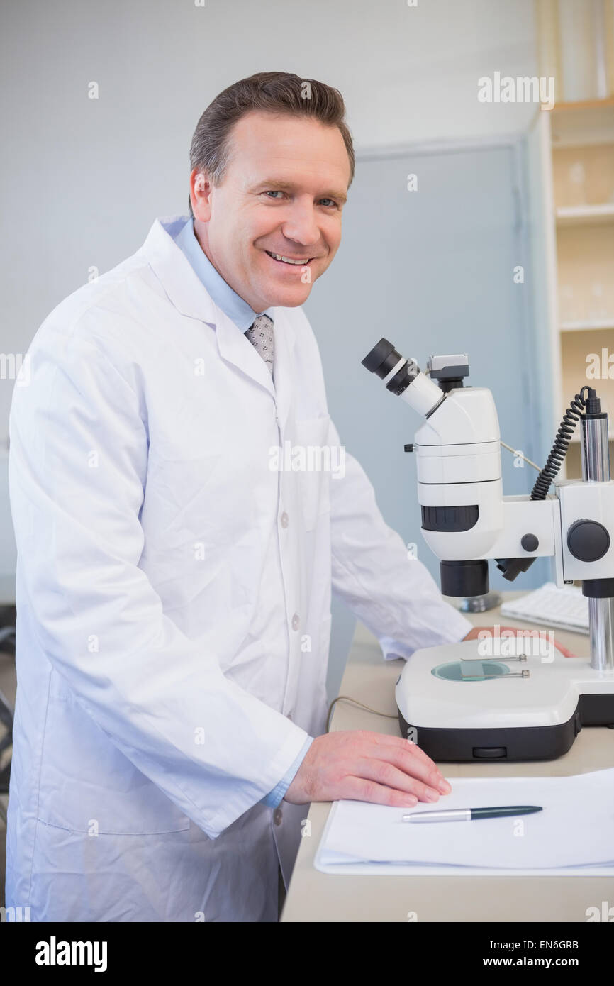 Smiling scientist examining sample with microscope Stock Photo - Alamy