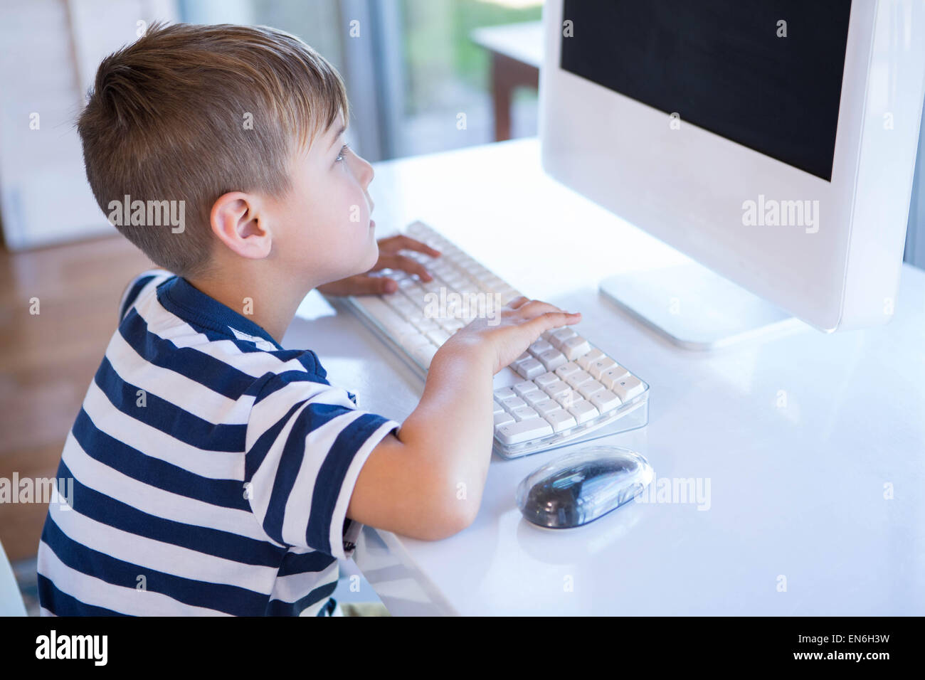 Little boy using computer in the living room Stock Photo - Alamy