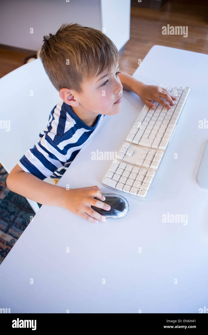 Little boy using computer in the living room Stock Photo - Alamy