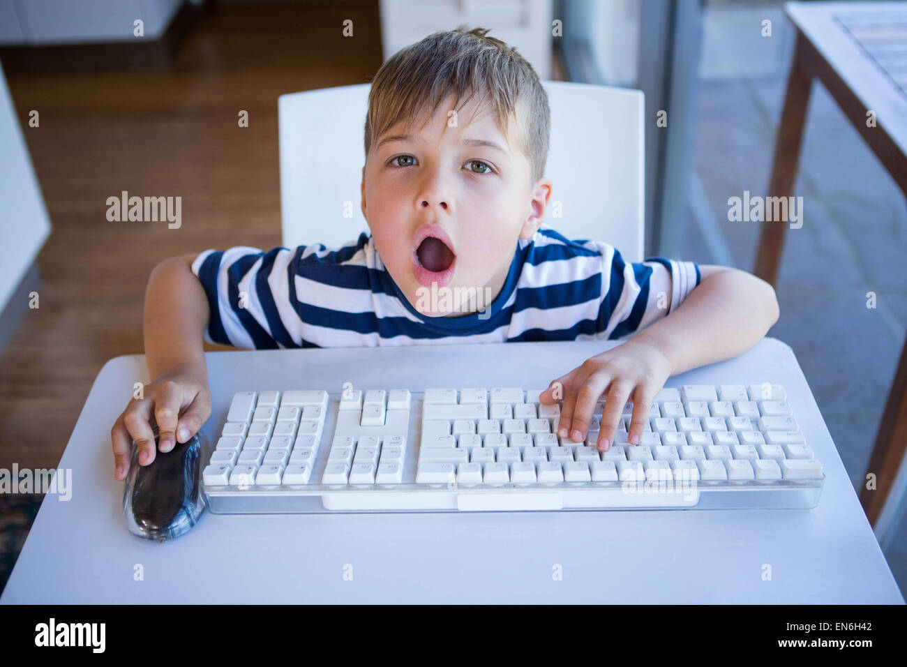 Little boy using computer in the living room Stock Photo - Alamy