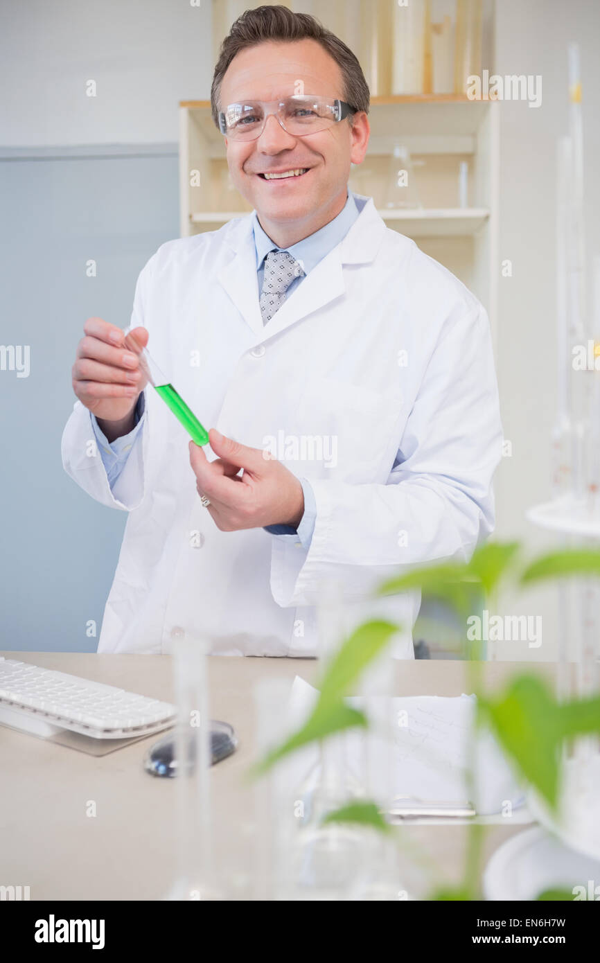 Scientist smiling at camera holding tube Stock Photo - Alamy