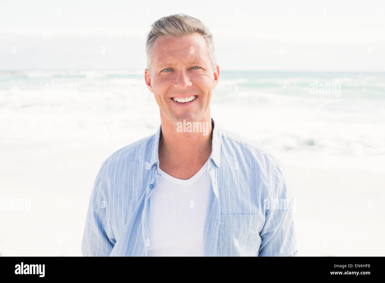 Handsome man smiling at camera Stock Photo - Alamy