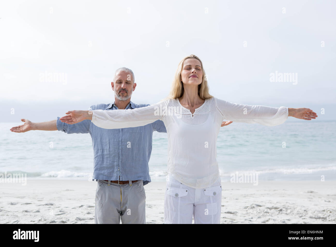 Happy couple doing yoga together Stock Photo - Alamy