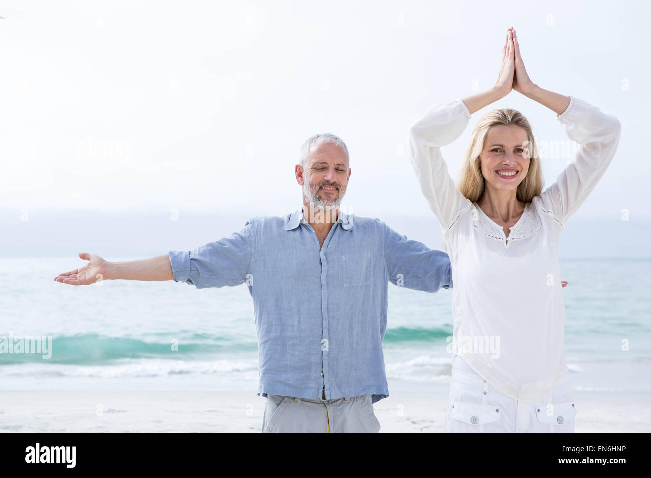 Happy couple doing yoga together Stock Photo - Alamy