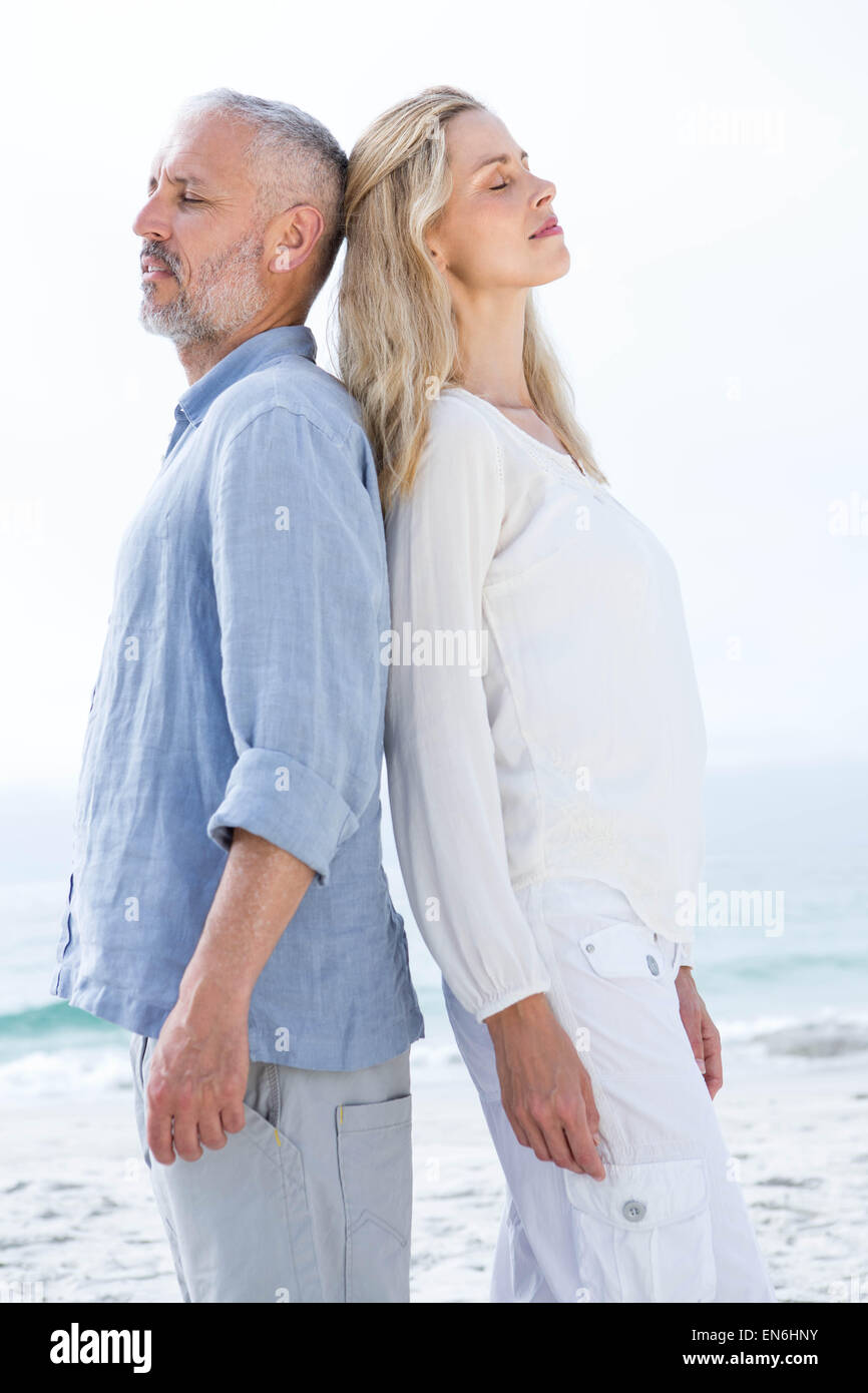 Happy couple standing back to back Stock Photo - Alamy
