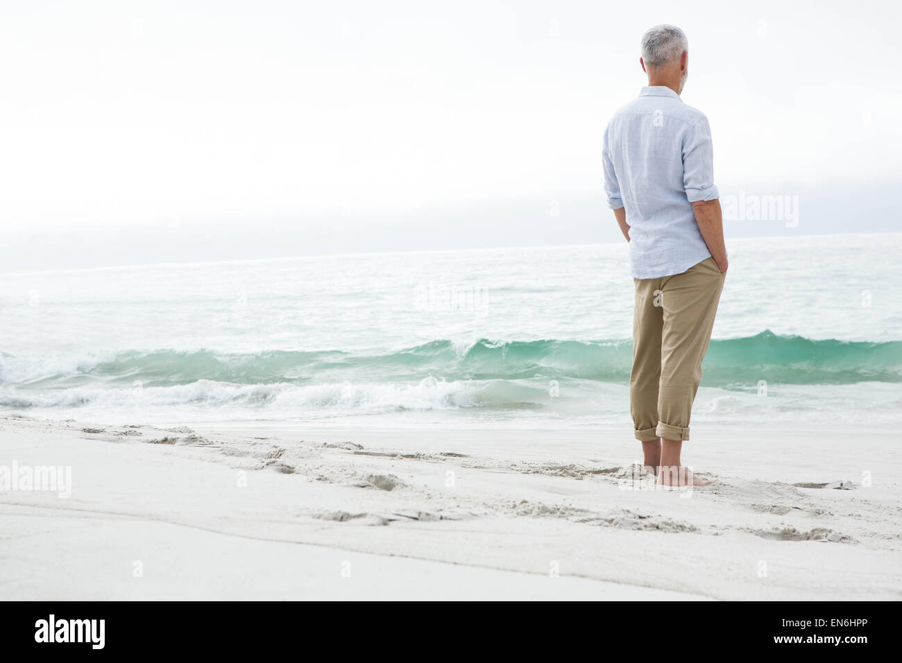 Thoughtful man standing by the sea Stock Photo - Alamy