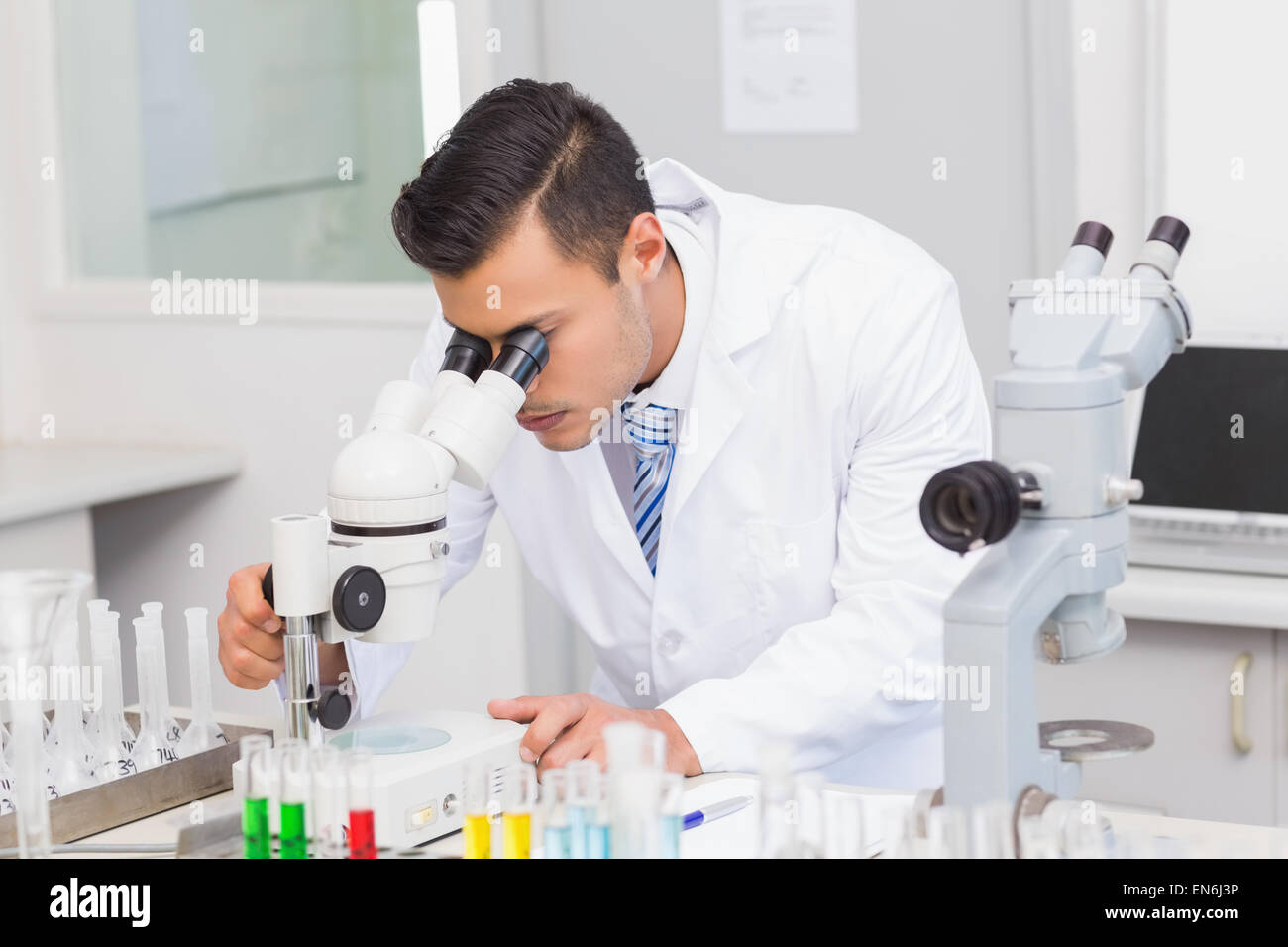 Serious scientist using microscope Stock Photo - Alamy