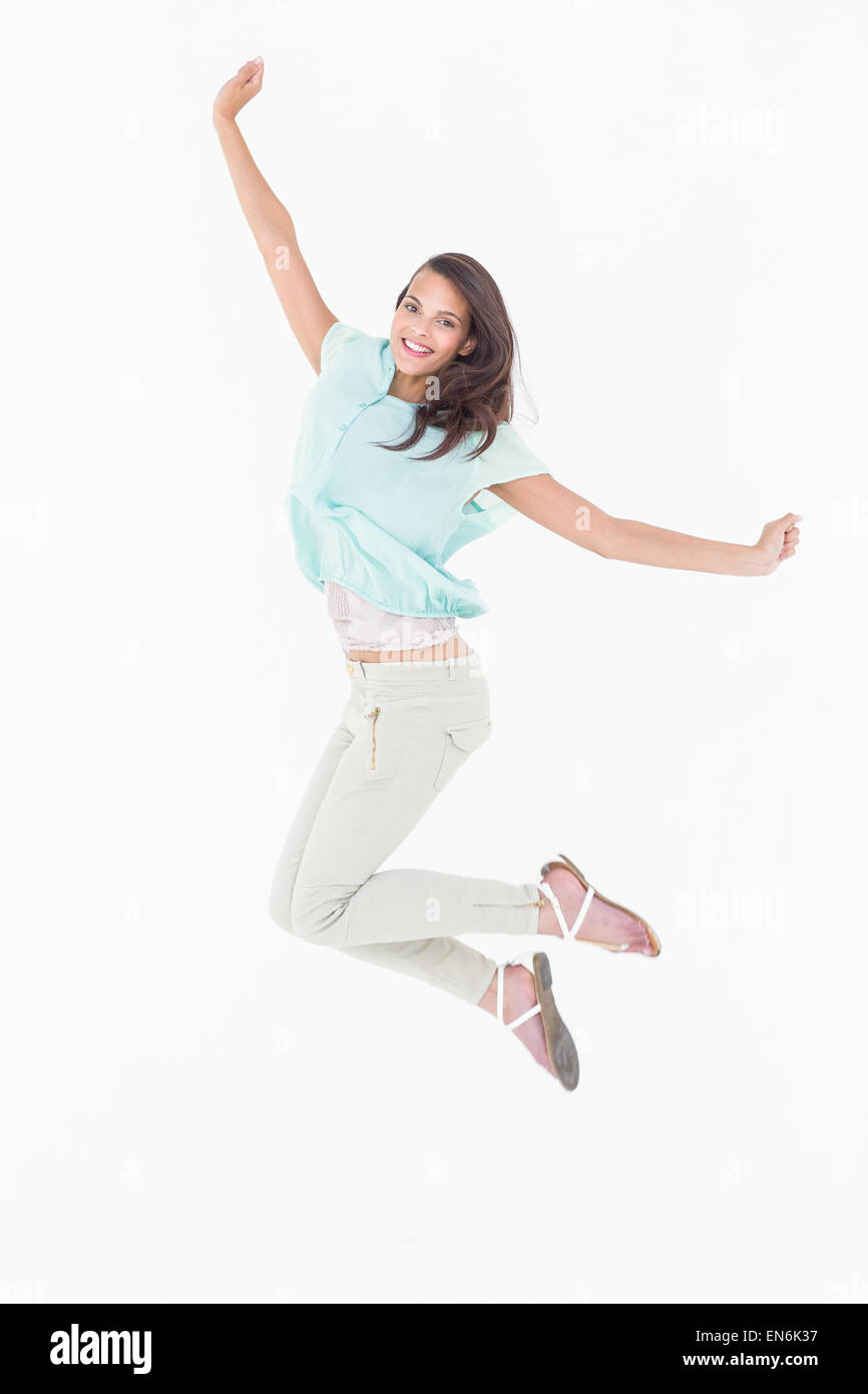 Pretty woman jumping looking at camera Stock Photo - Alamy