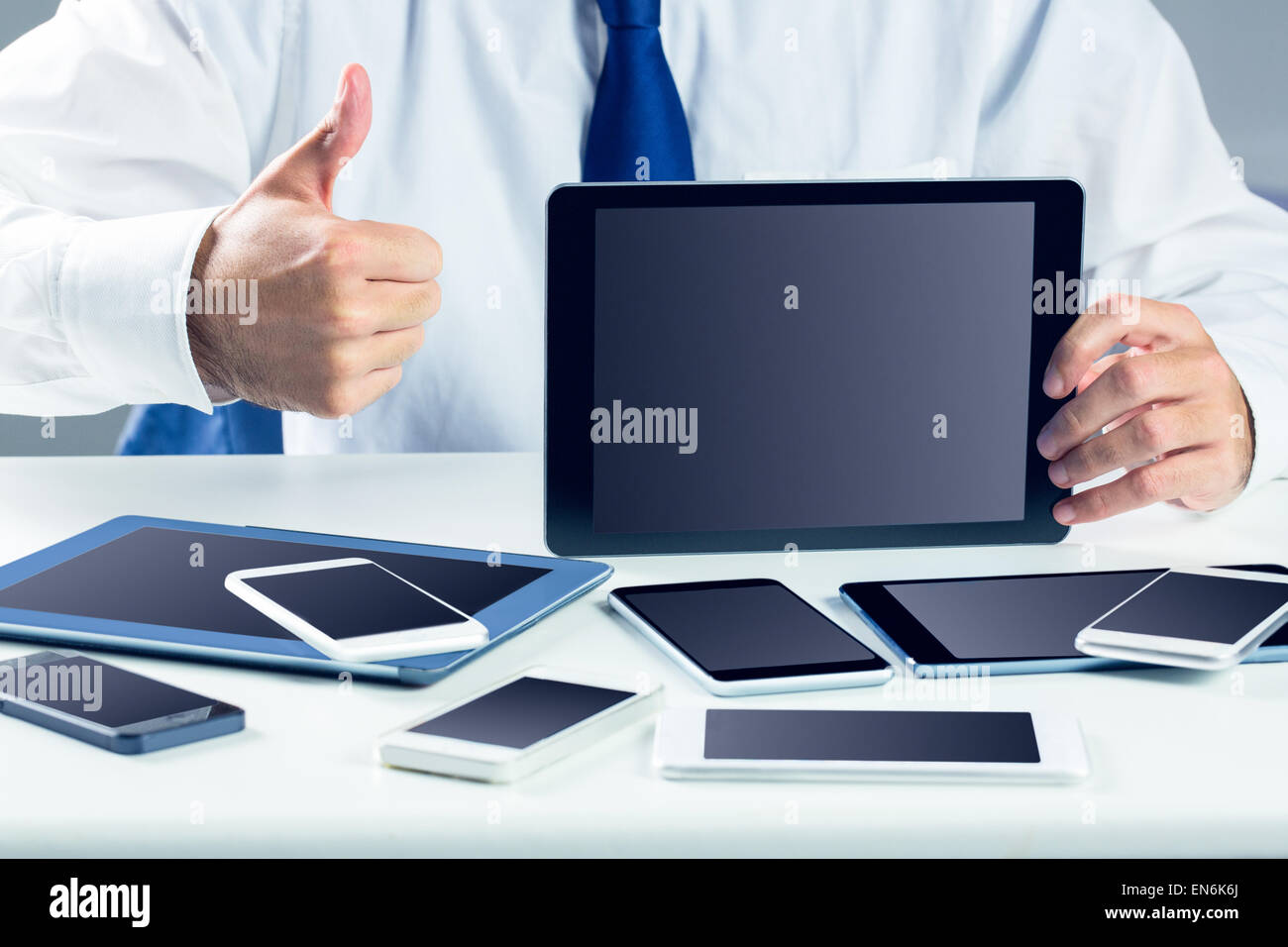Businessman with smartphones and tablet Stock Photo - Alamy