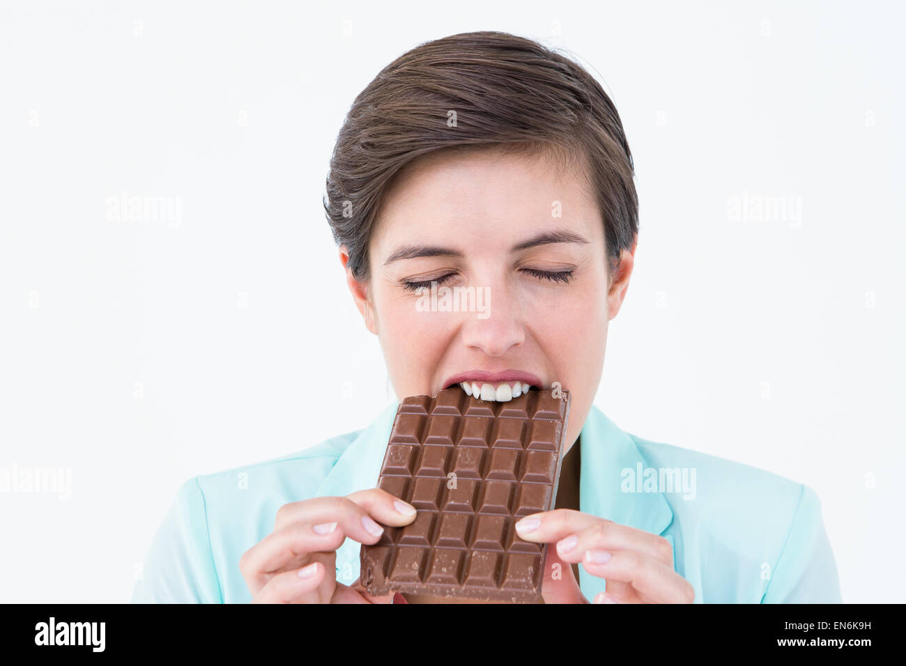 Brunette eating bar of chocolate Stock Photo - Alamy