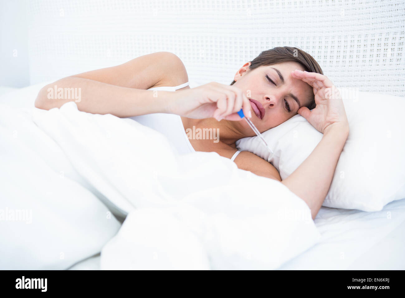 Sick woman looking at her thermometer Stock Photo - Alamy