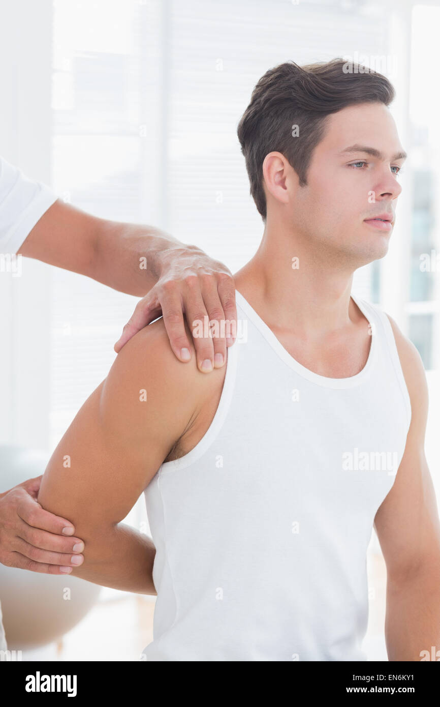 Doctor stretching a young man arm Stock Photo - Alamy