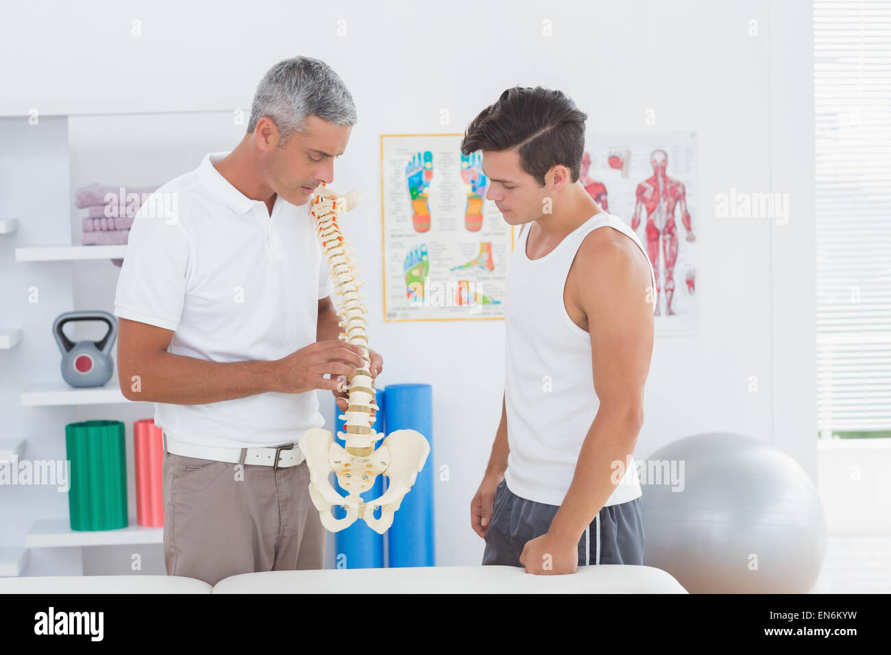 Doctor showing anatomical spine to his patient Stock Photo - Alamy