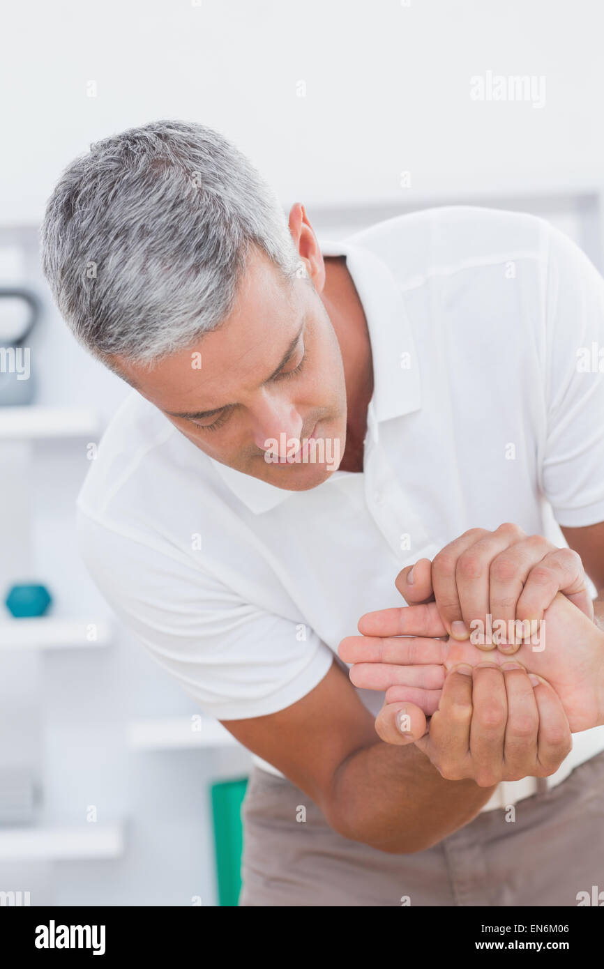 Doctor examining a male patients hand Stock Photo - Alamy