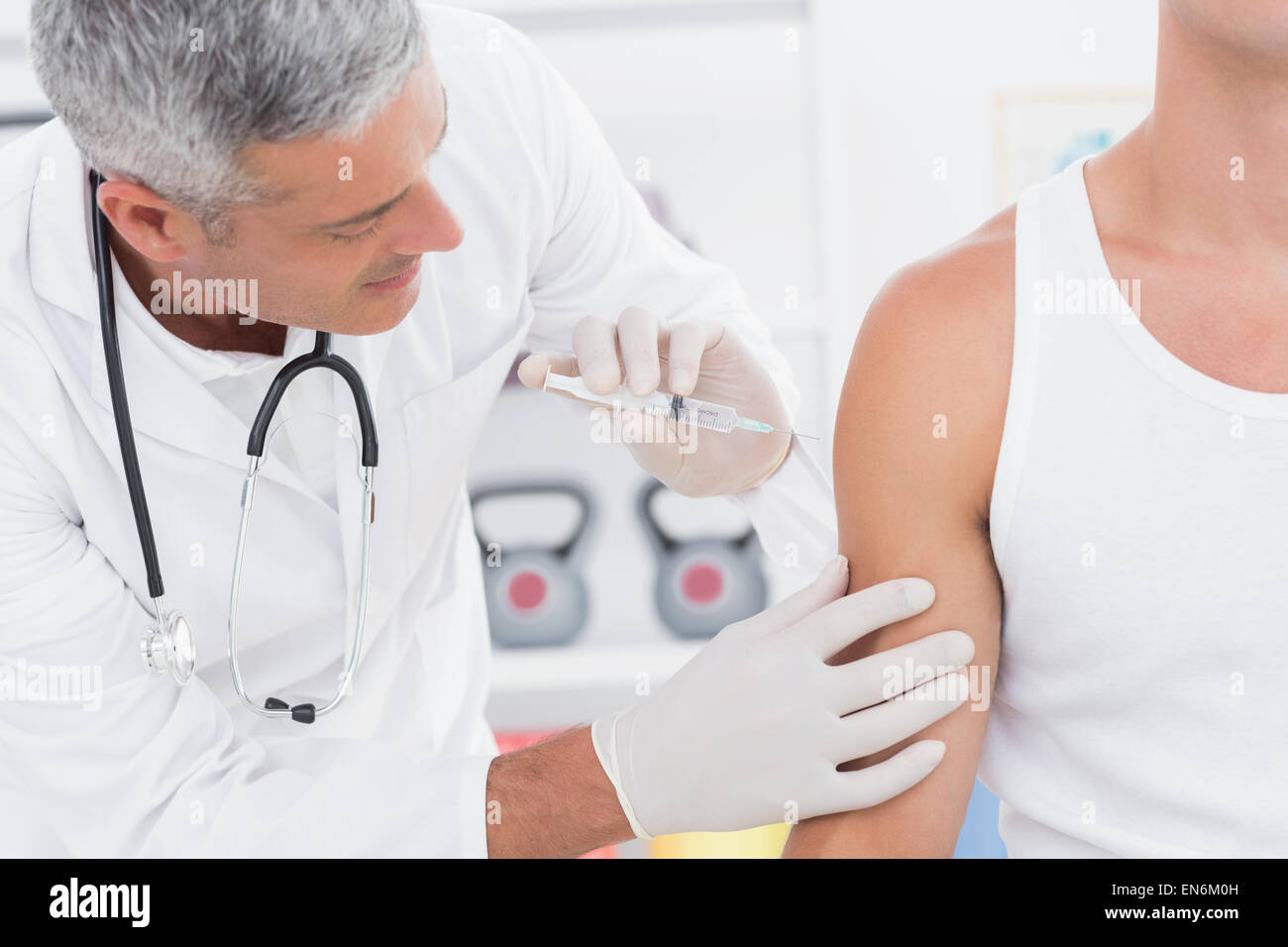 Doctor doing an injection to his patient Stock Photo - Alamy