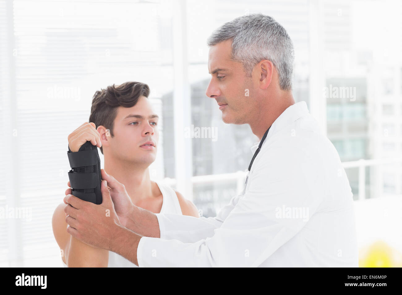 Doctor examining a man wrist Stock Photo - Alamy