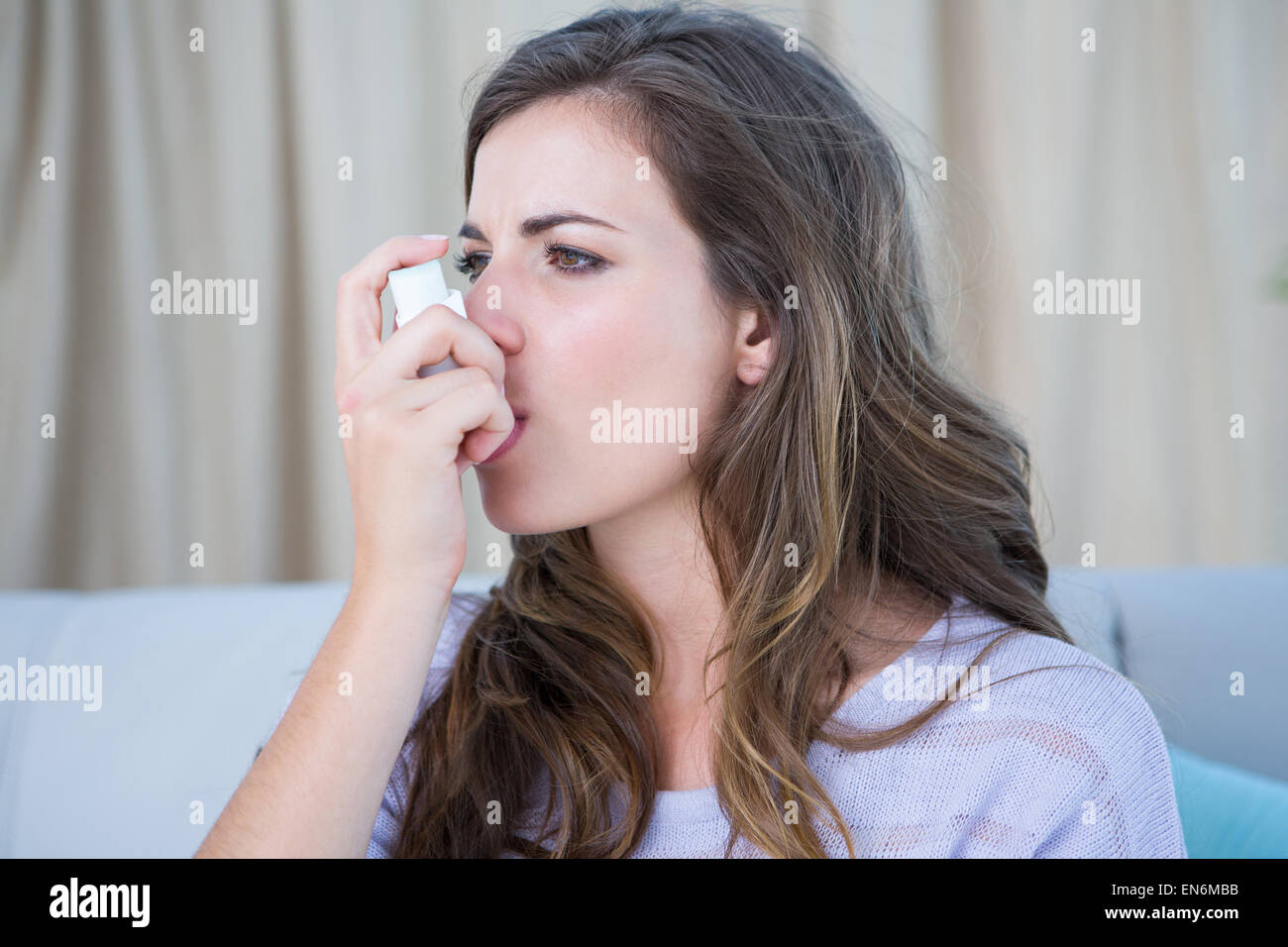 Pretty woman taking her inhaler Stock Photo - Alamy