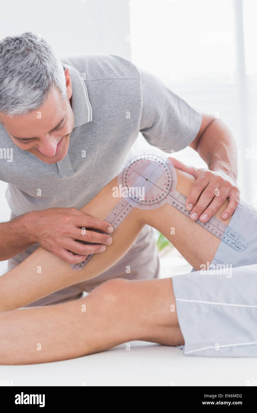 Doctor examining man leg Stock Photo - Alamy