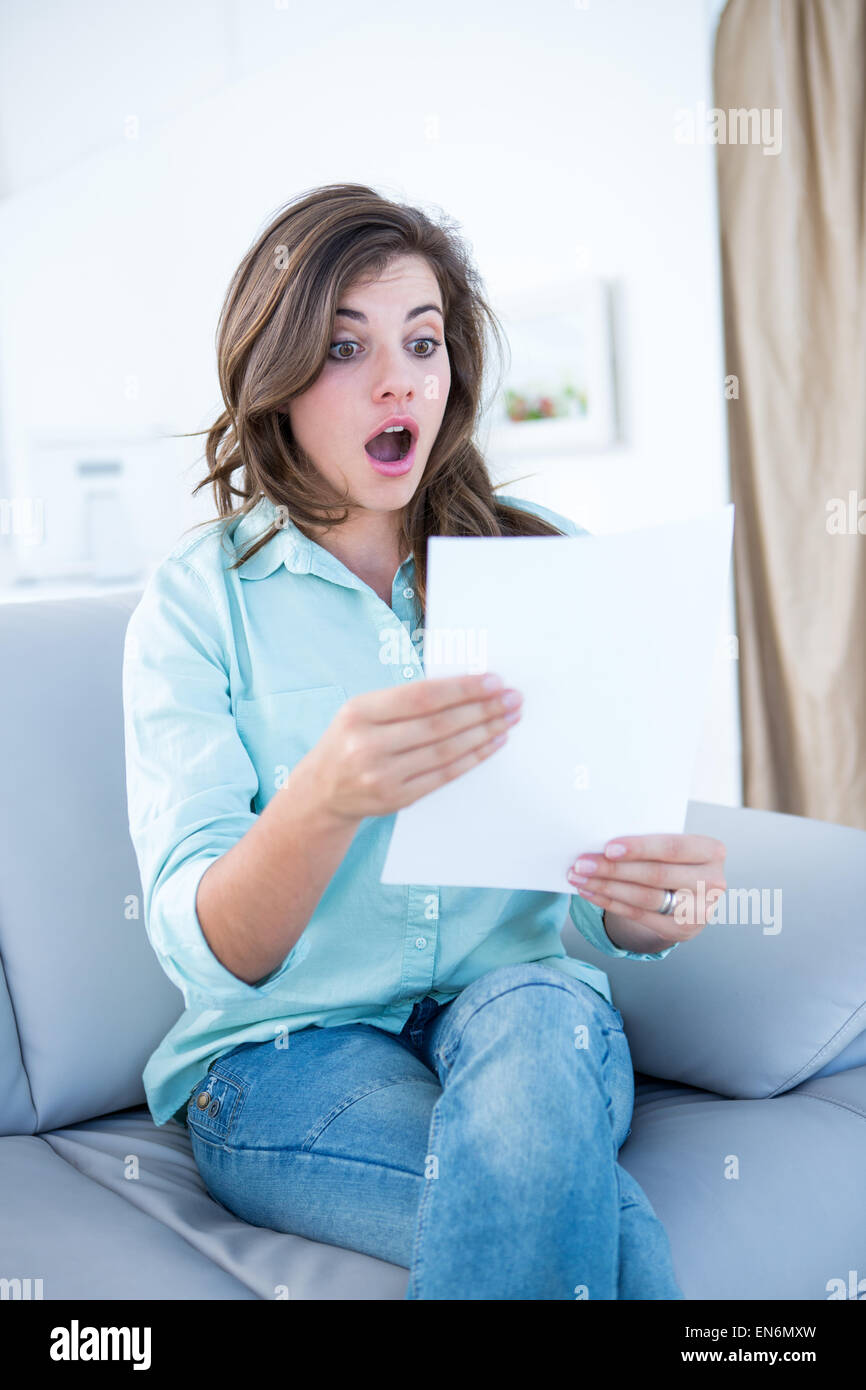 Shocked brunette looking a paper Stock Photo - Alamy