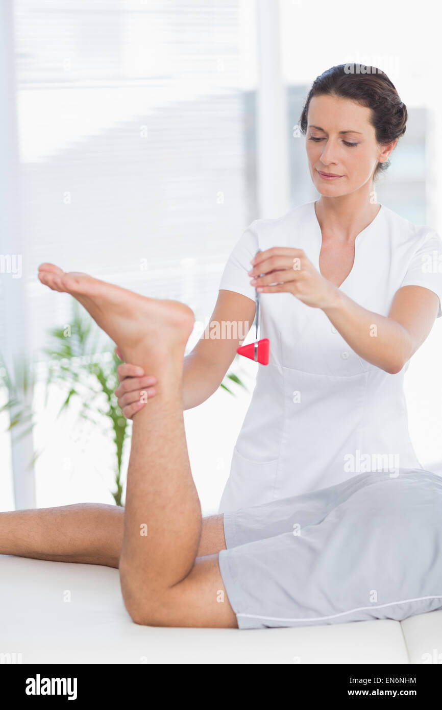 Physiotherapist using reflex hammer Stock Photo - Alamy