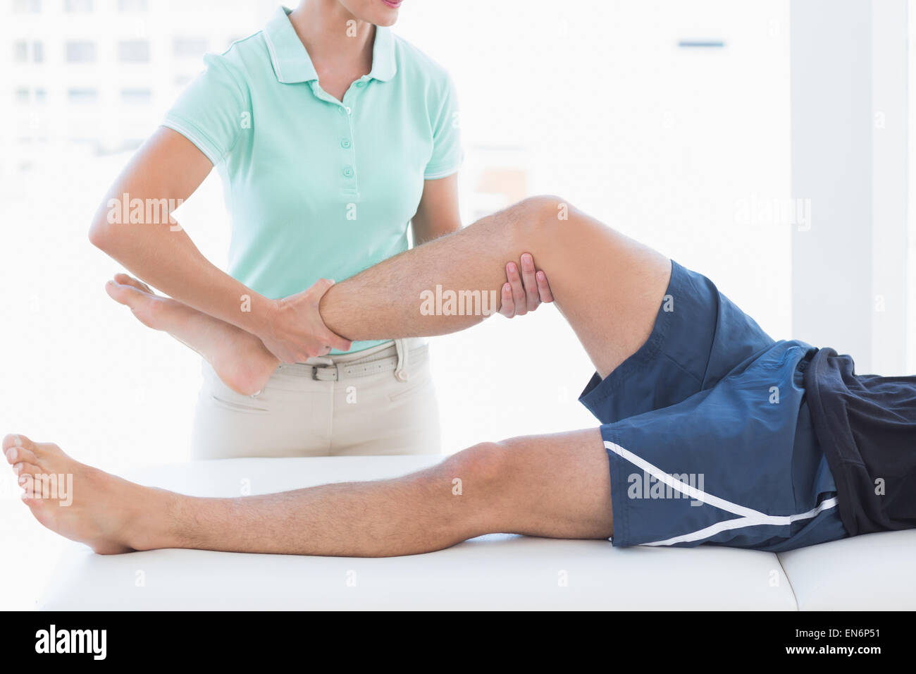 Doctor examining man leg Stock Photo - Alamy