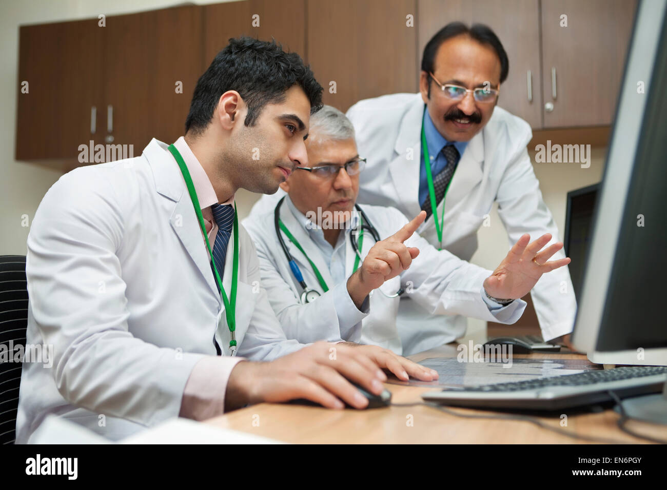 Doctors looking at computer screen Stock Photo - Alamy