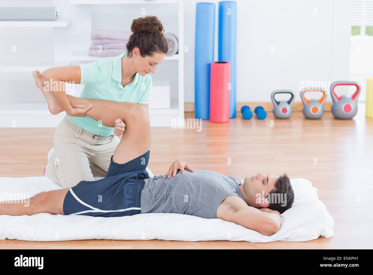 Man stretching with his trainer Stock Photo - Alamy