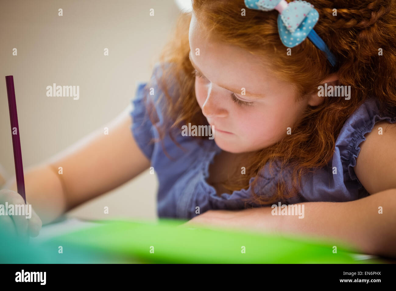 Pupil working hard at desk Stock Photo - Alamy