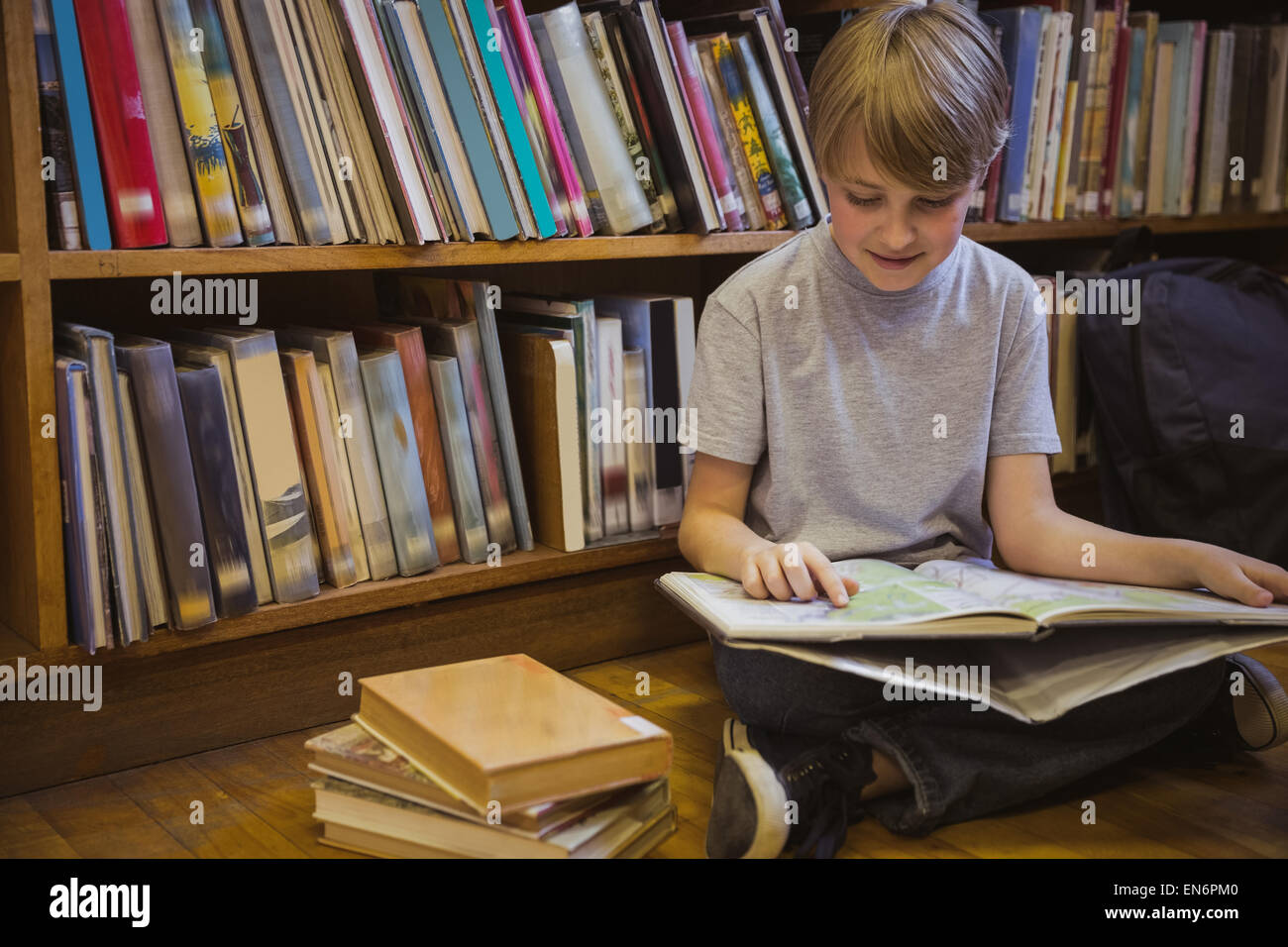 Little boy reading on library floor Stock Photo - Alamy