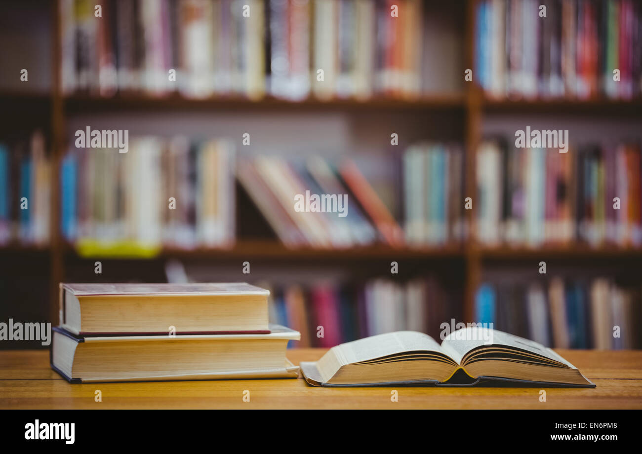 Books on desk in library Stock Photo - Alamy