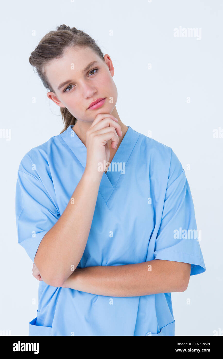 Thoughtful nurse looking at camera with hand on chin Stock Photo - Alamy