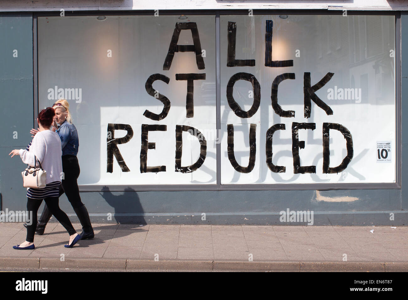 ALL STOCK REDUCED sign on high street shop window where the economic ...