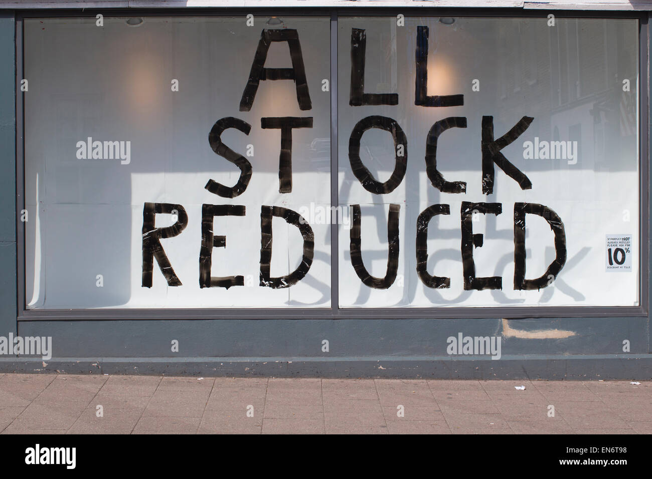ALL STOCK REDUCED sign on high street shop window where the economic ...