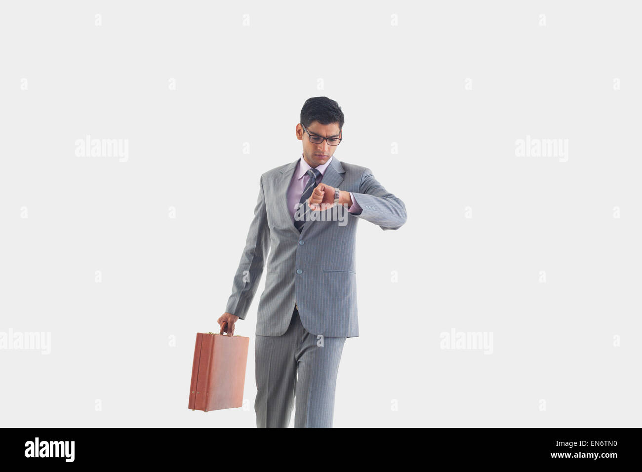 Businessman looking at watch Stock Photo - Alamy