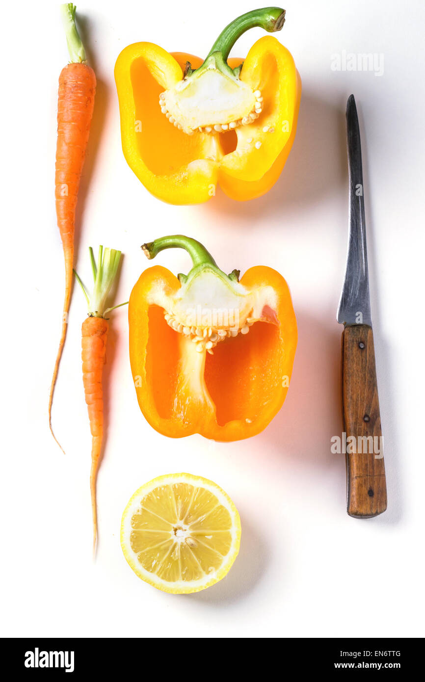 Set of whole and sliced red, orange and yellow vegetables over white ...