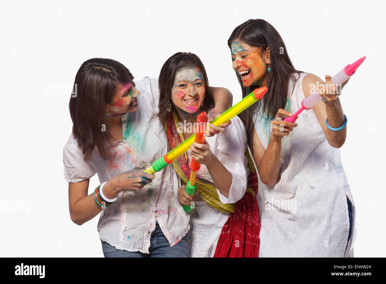 Three women playing holi Stock Photo - Alamy