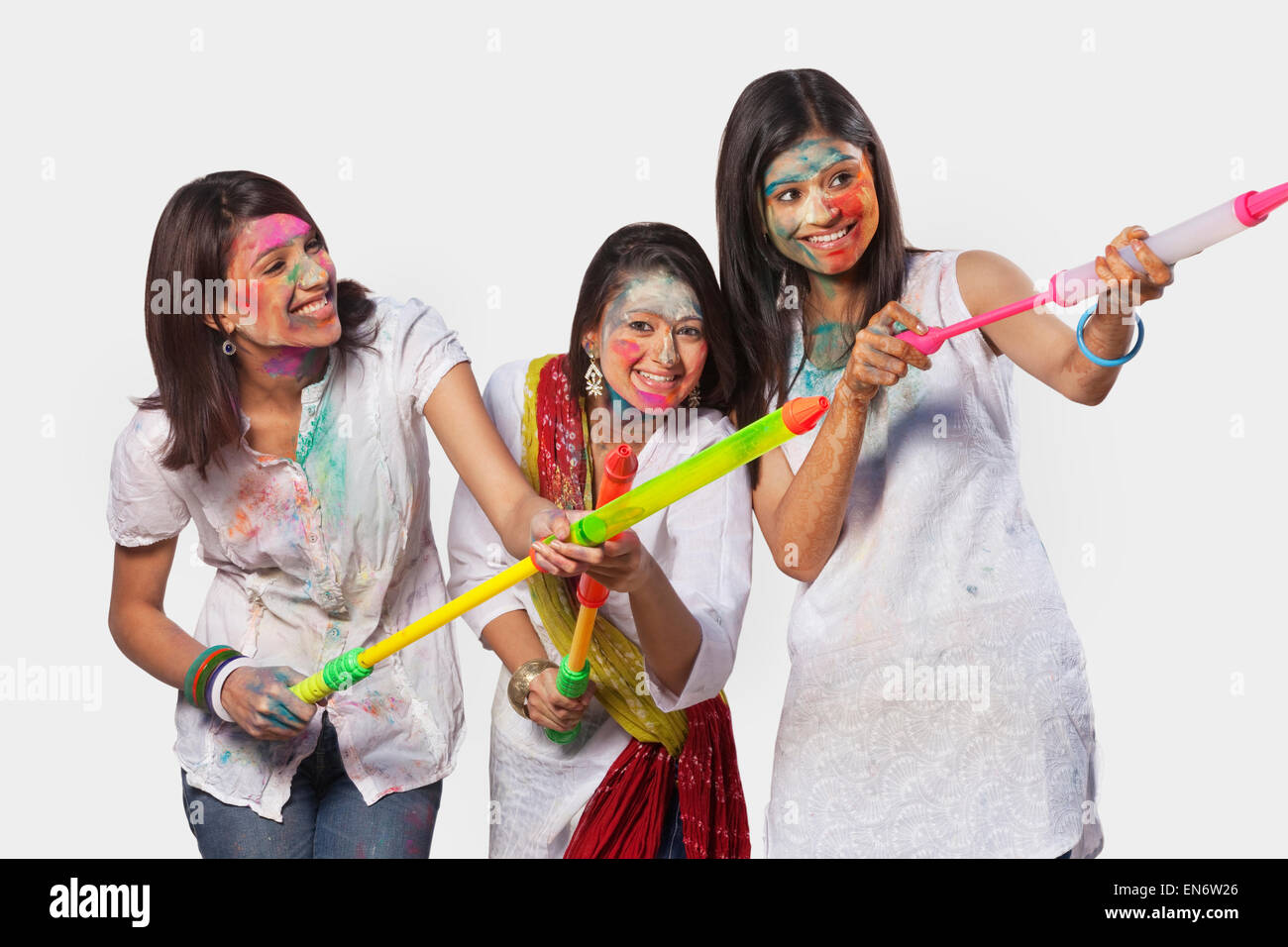 Three women playing holi Stock Photo - Alamy