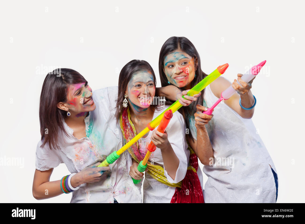 Three women playing holi Stock Photo - Alamy